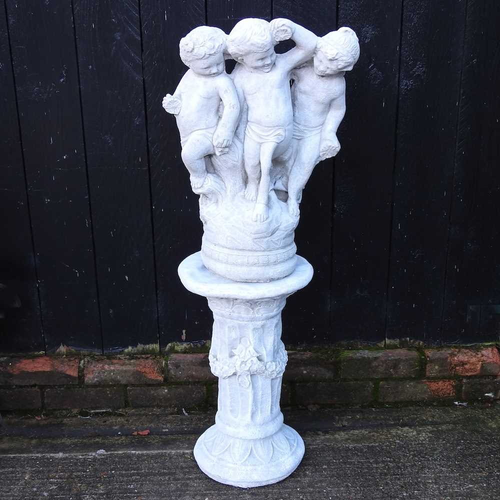 Lot 656 - A cast stone garden statue, of three cherubs