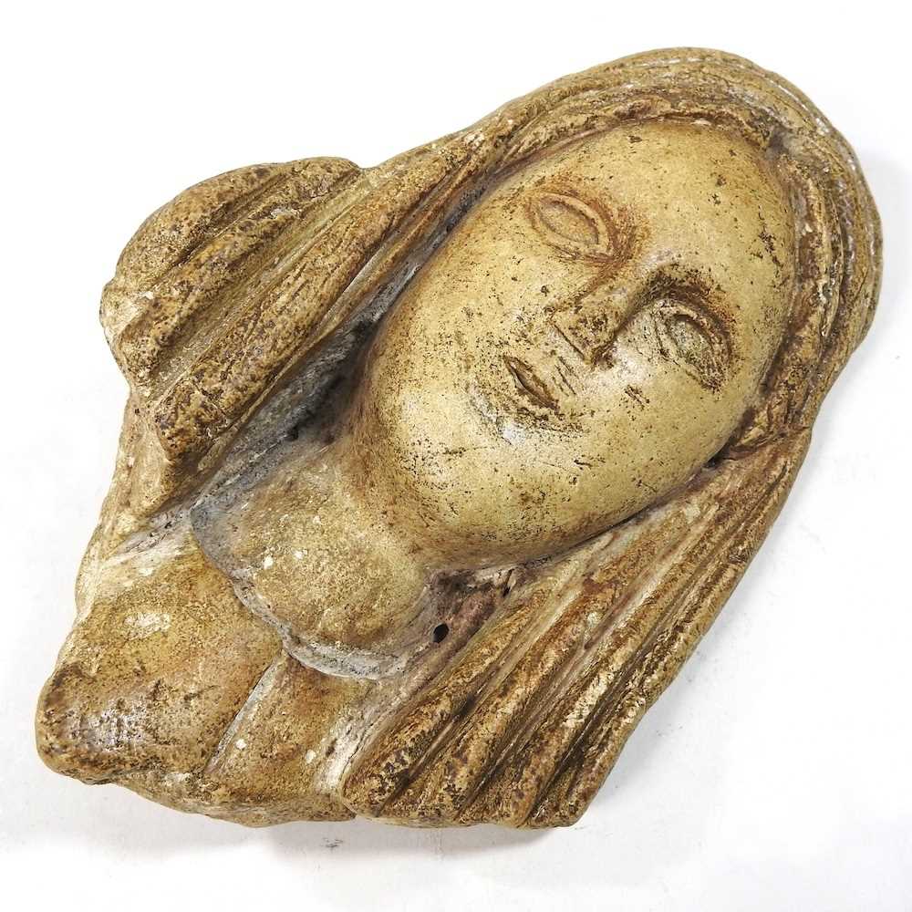 Lot 292 - A carved stone fragment, carved as a head,