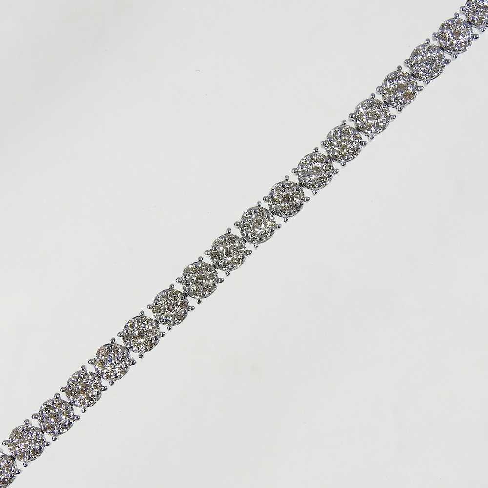 Lot 413 - A 9 carat white gold diamond set line