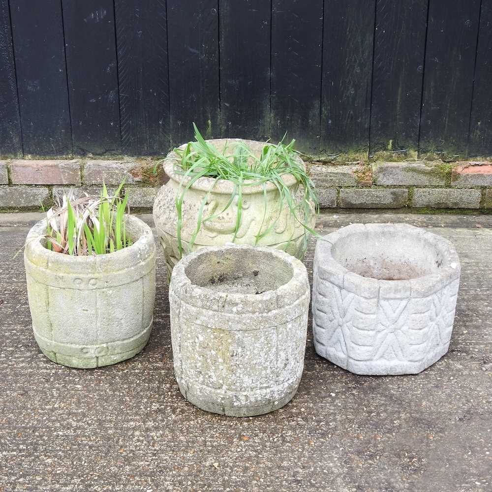 Lot 656 - A collection of four cast stone garden pots
