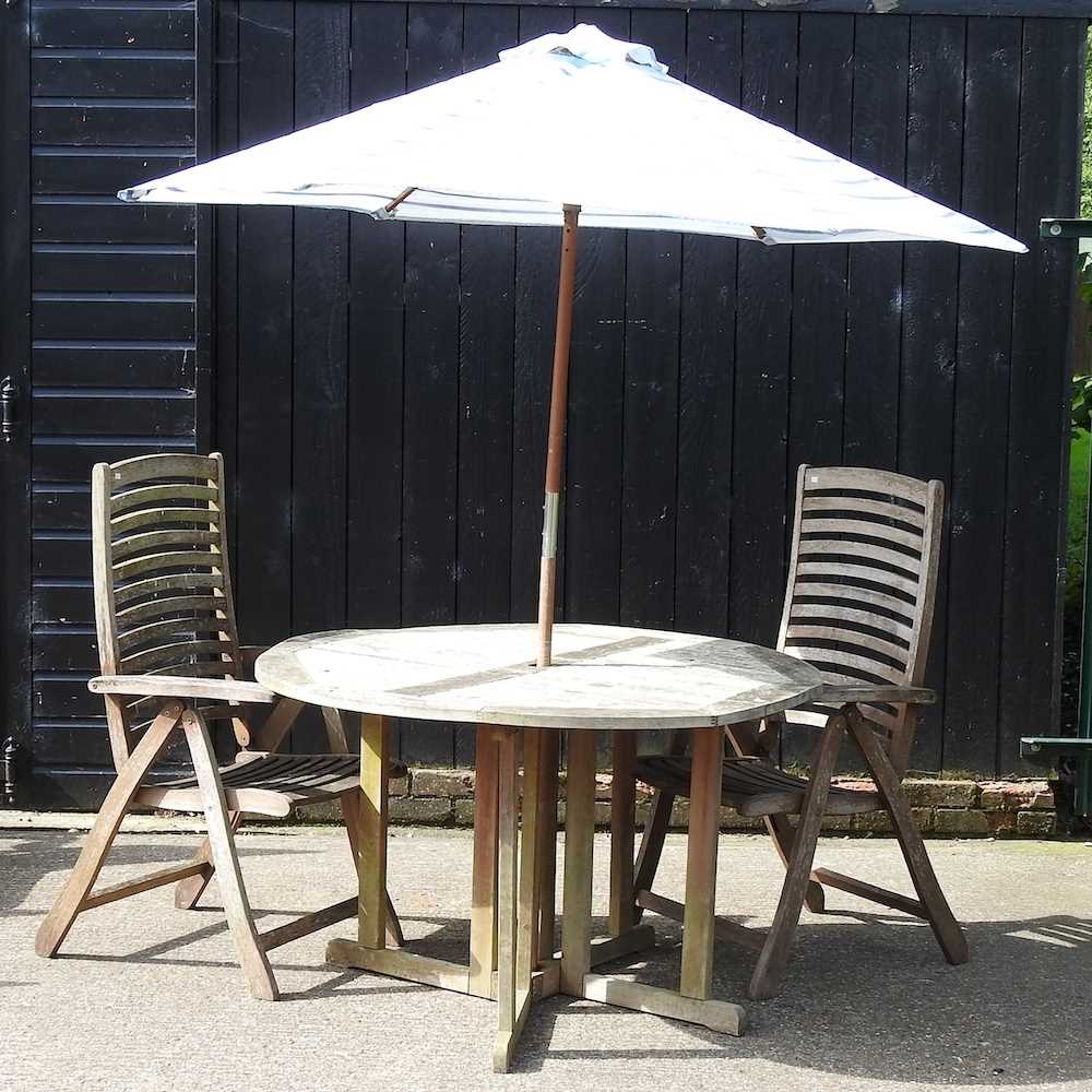Lot 157 - A teak circular drop leaf garden table,
