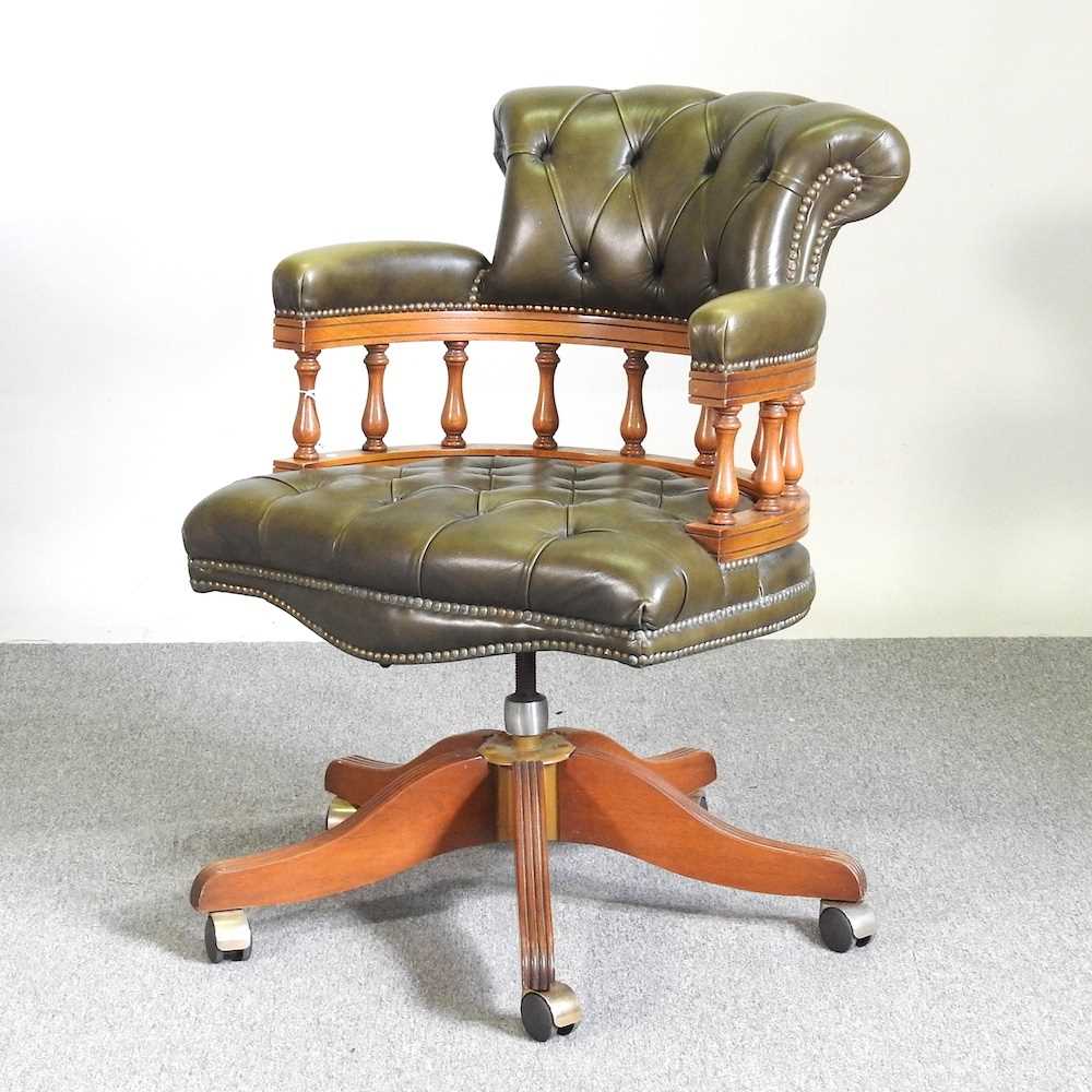 Lot 407 - A green leather upholstered revolving desk