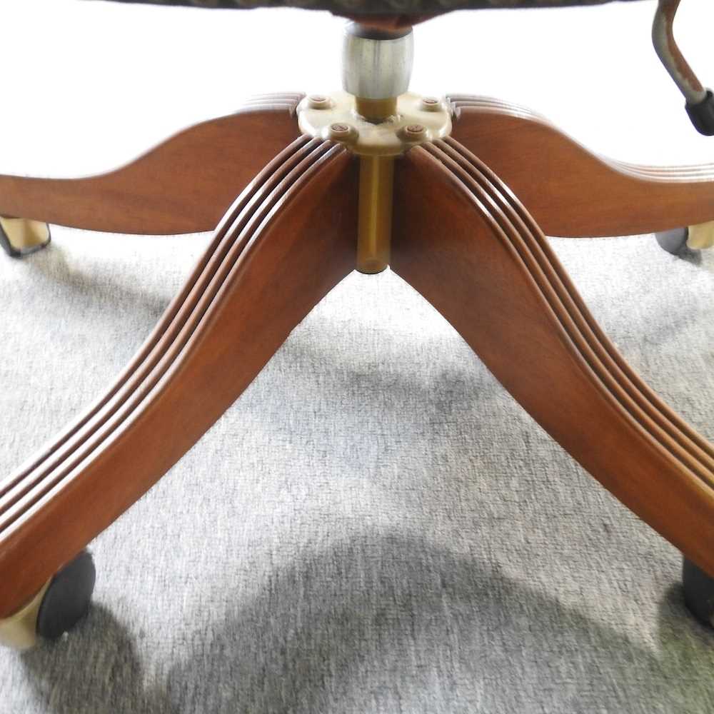 Lot 407 - A green leather upholstered revolving desk