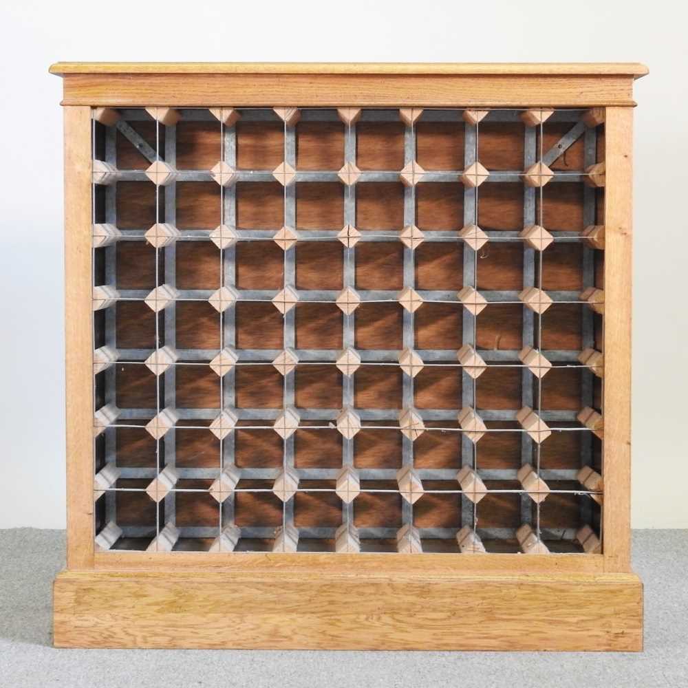 Lot 105 - A handmade oak wine rack, on a plinth base