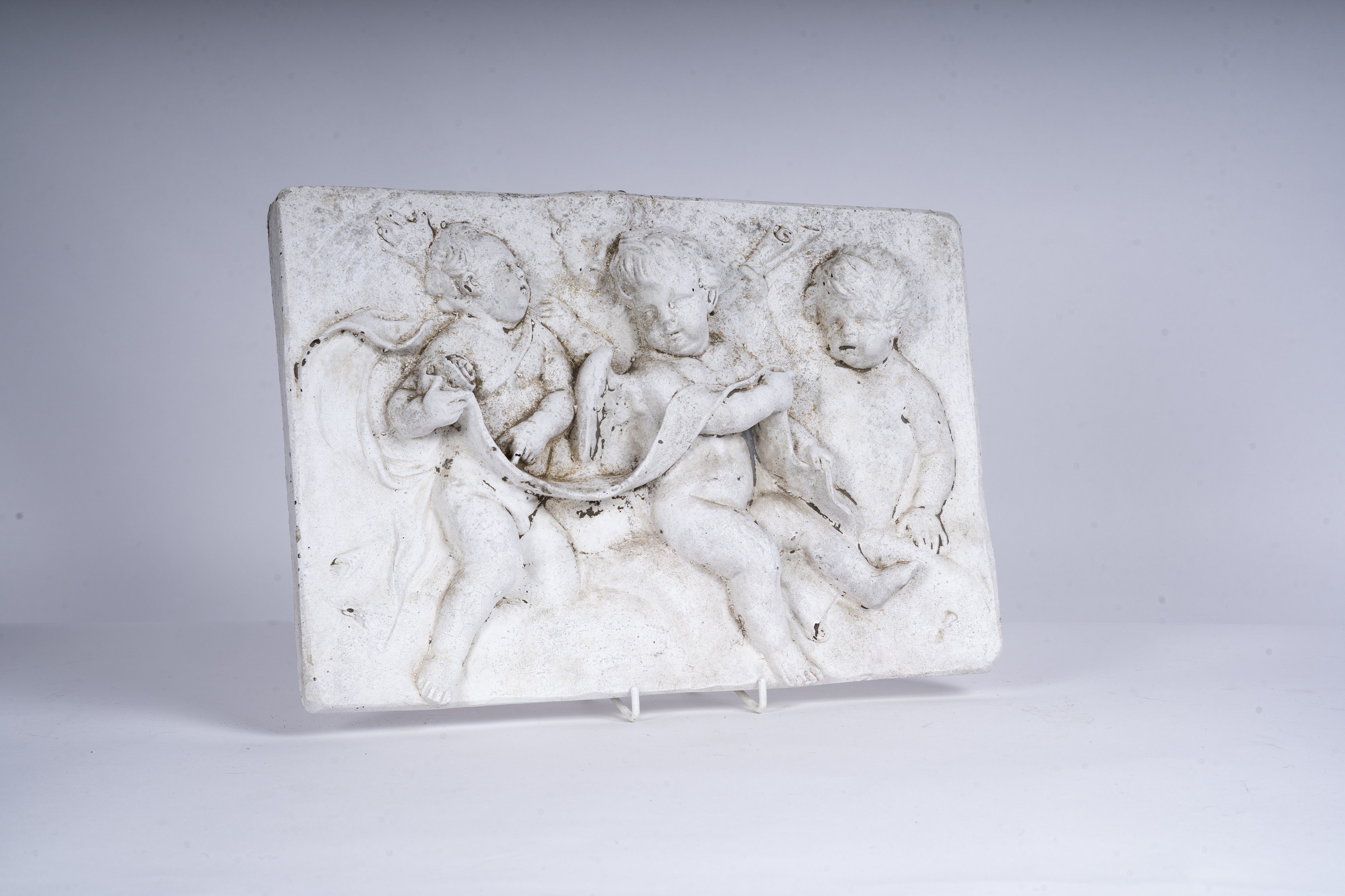 Lot 153 - A plaster panel, relief decorated with putti,