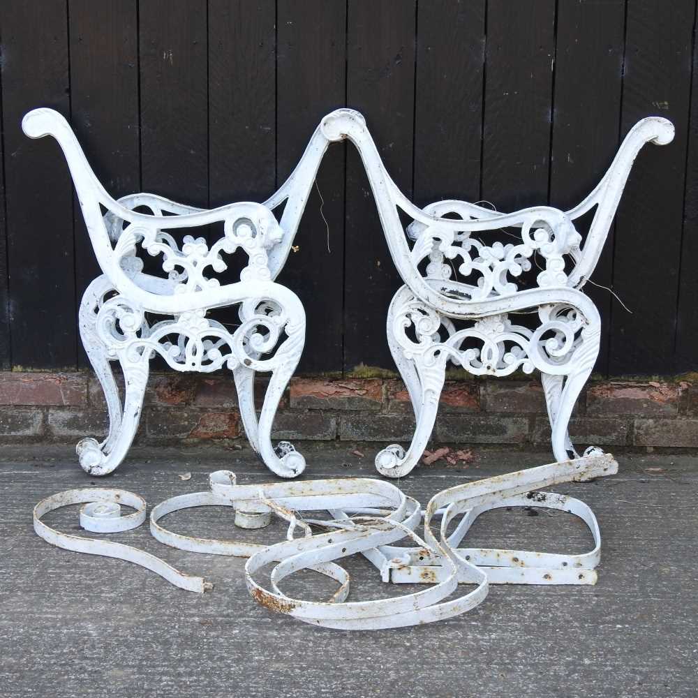 Lot 674 - A pair of white painted metal bench ends,