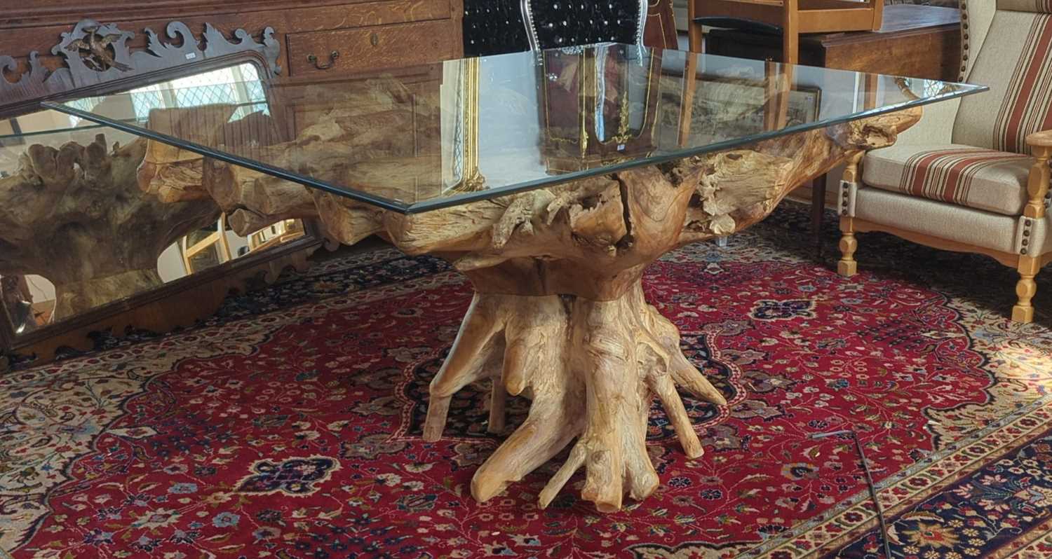 Lot 495 - A square glass table on a carved teak