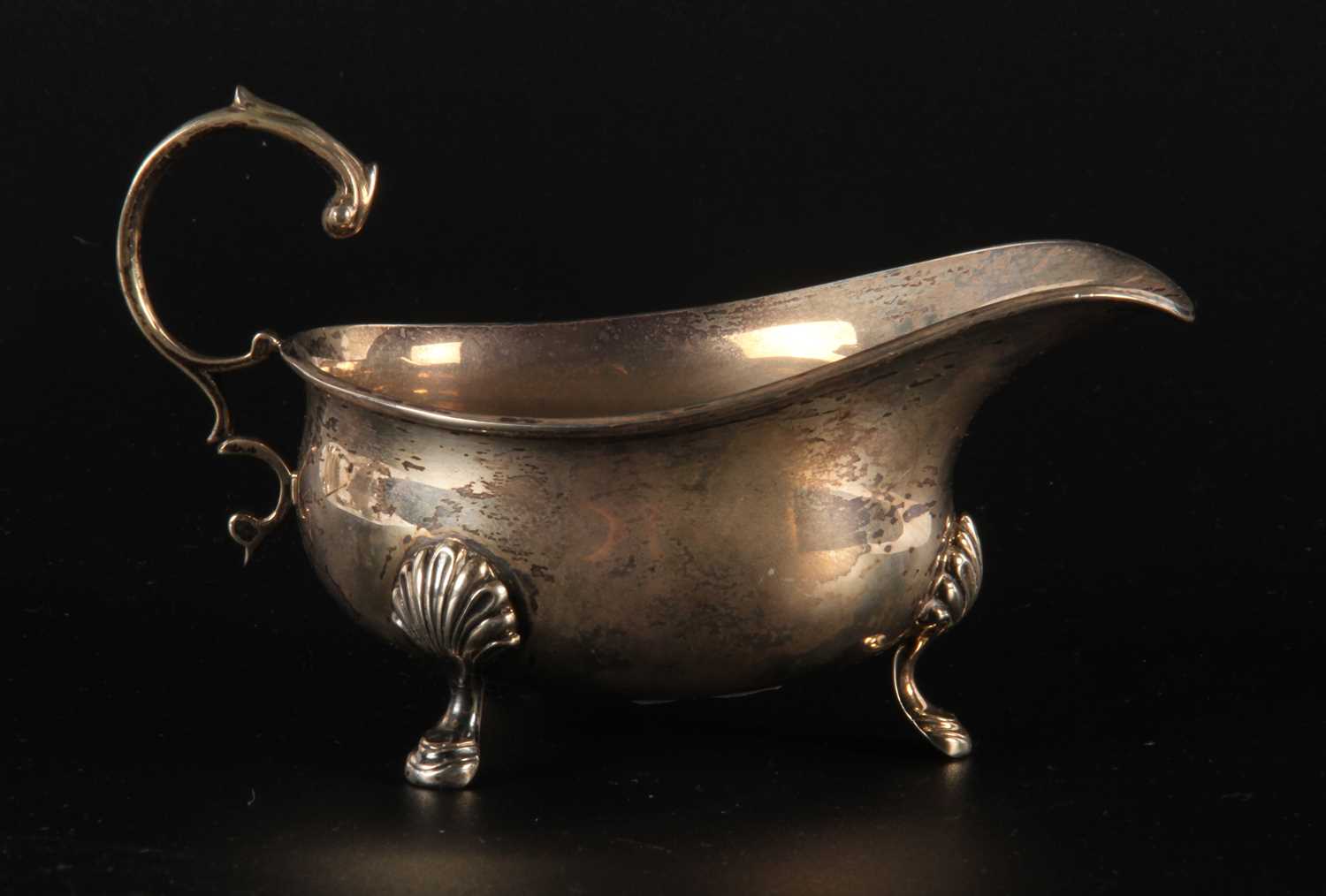 Lot 96 - A George V silver sauce boat, of helmet shape,